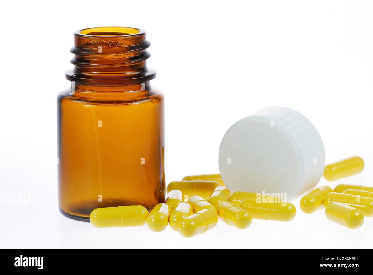 Yellow pharmaceutical capsules in brown glass Stock Photo - Alamy