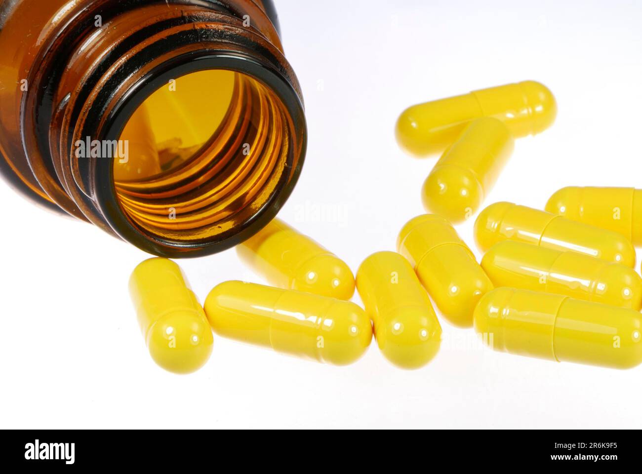 Yellow pharmaceutical capsules in brown glass Stock Photo - Alamy