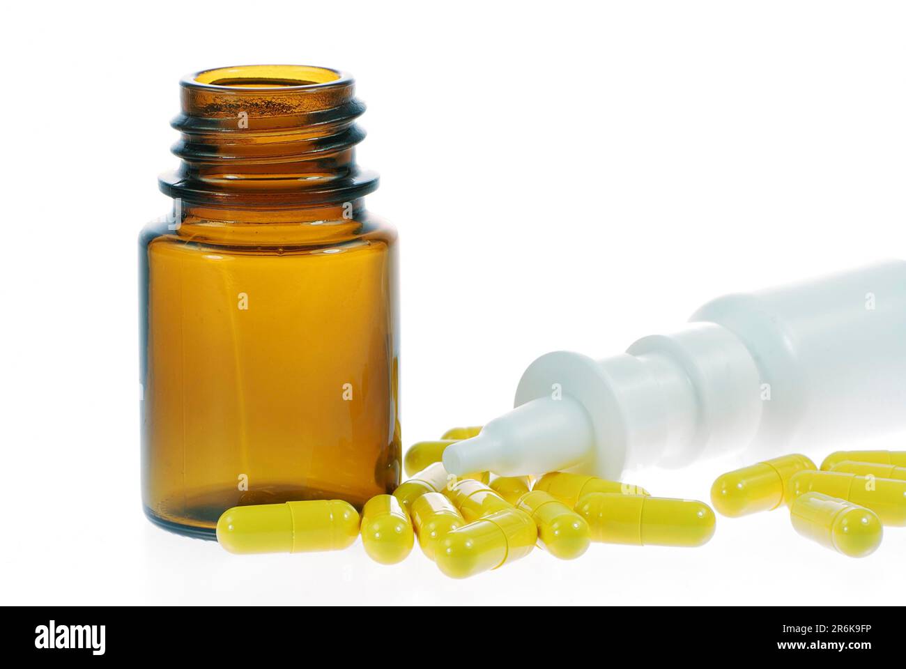 Nasal spray and yellow medical capsules Stock Photo - Alamy