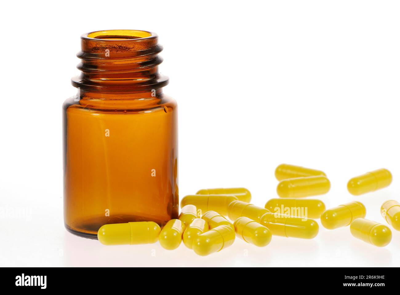 Yellow pharmaceutical capsules in brown glass Stock Photo - Alamy