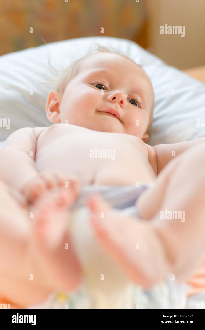 Little cute baby watches his feet Stock Photo - Alamy