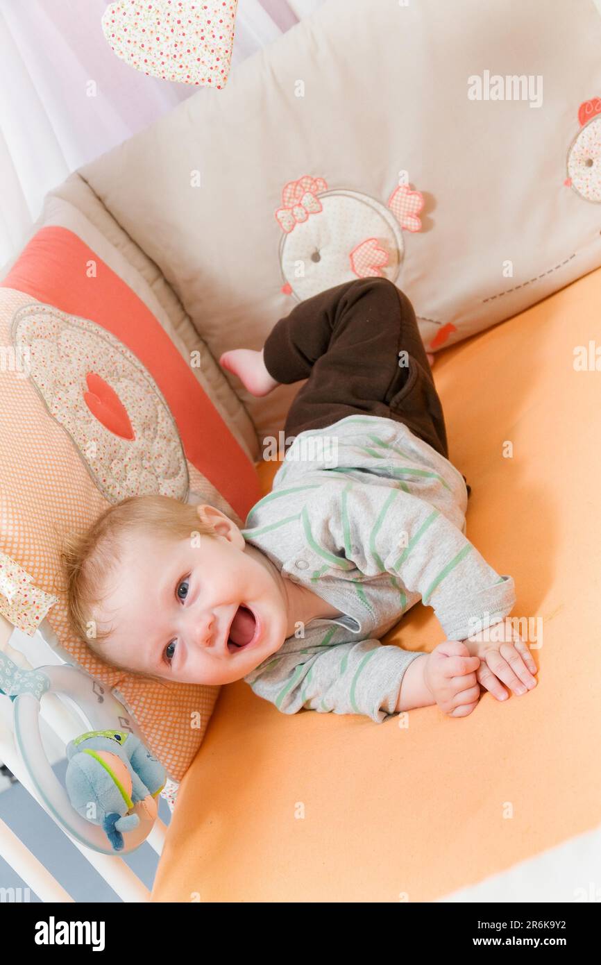 Toddler playing in a cosy cot Stock Photo - Alamy