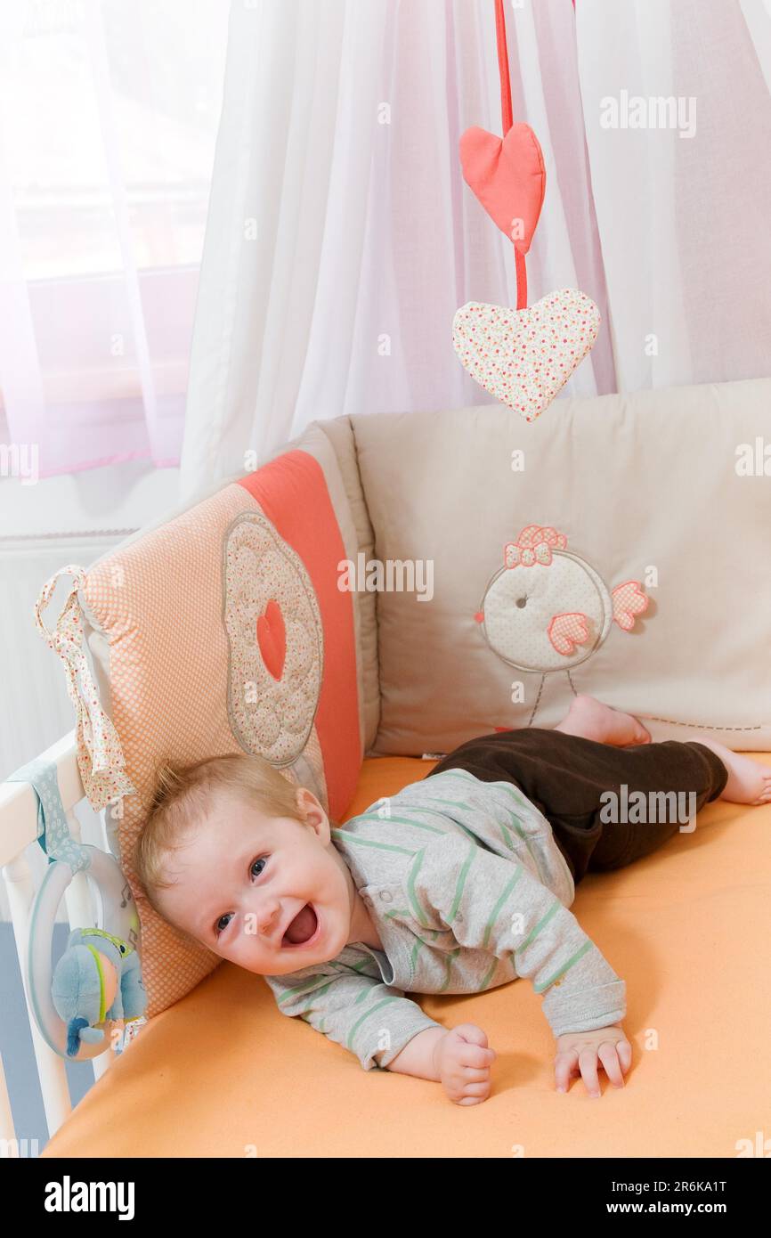 Toddler playing in a cosy cot Stock Photo - Alamy
