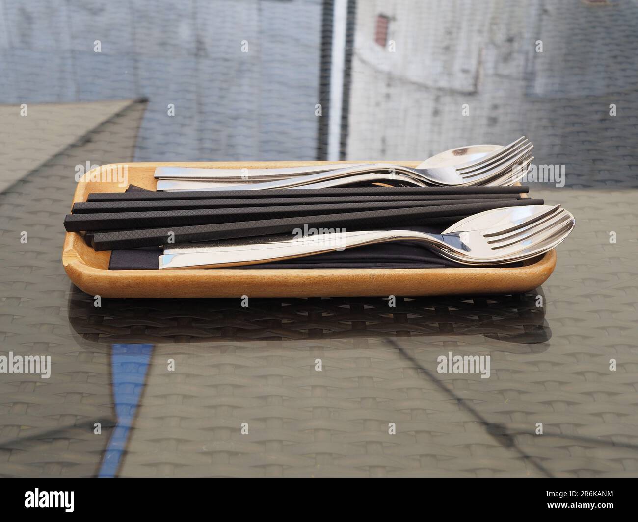 European Asian cutlery with fork, spoon and chopsticks in a wooden bowl ...