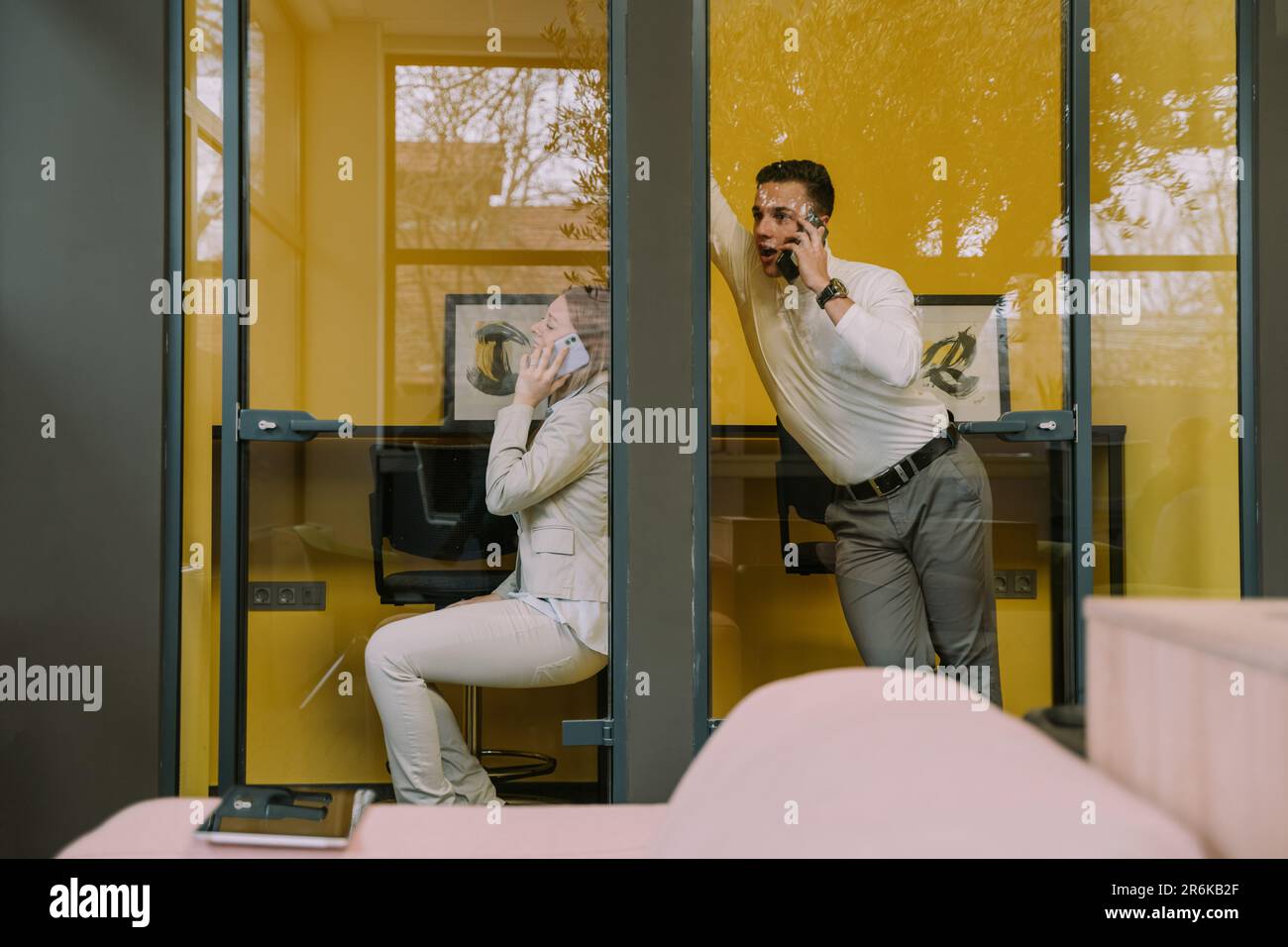 Two attractive male and female coworkers having a phone call in the ...