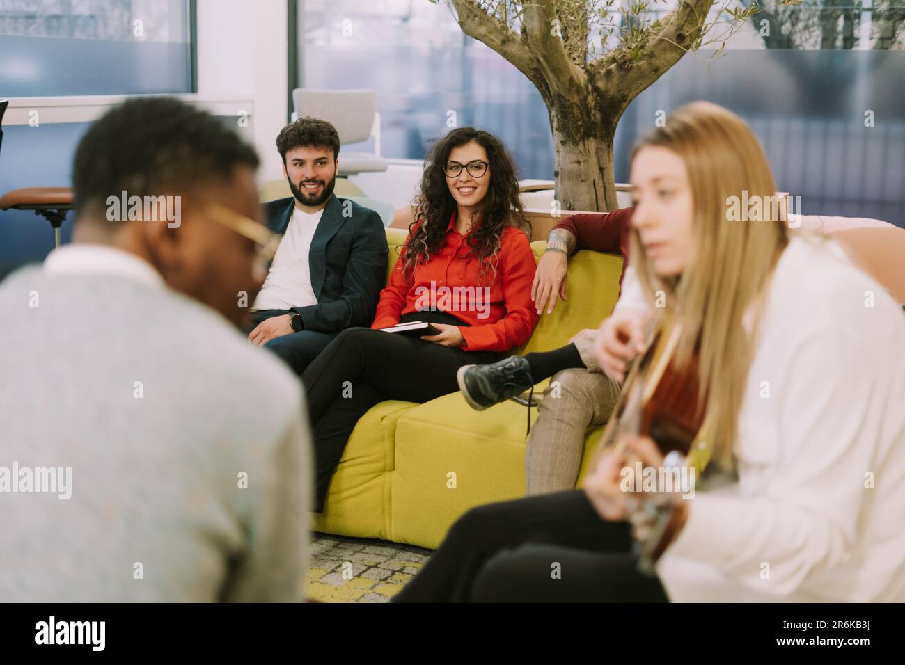 Karaoke party at the office. Young coworkers enjoying listening to ...