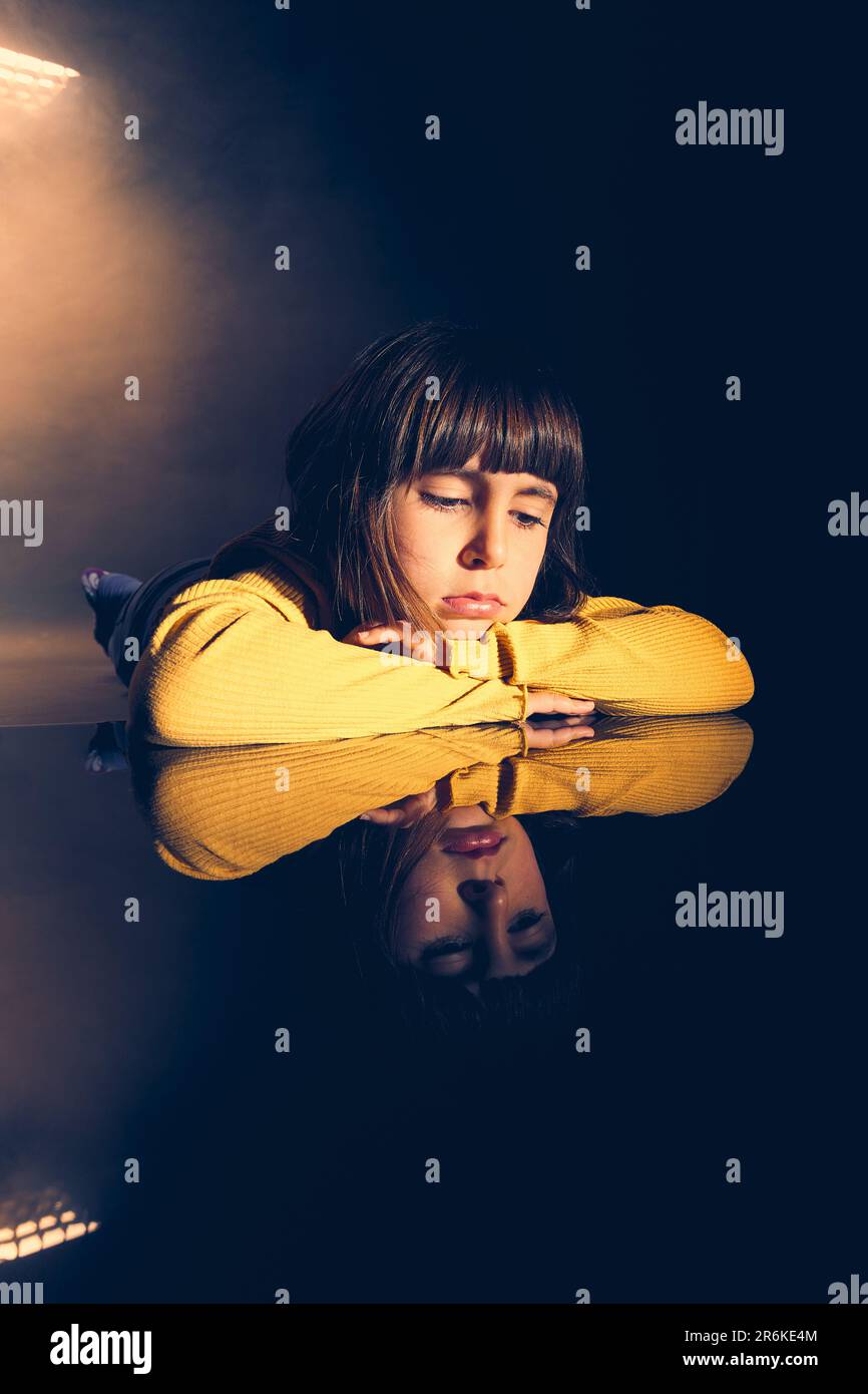 young girl with a depressed and sad face with her face reflected in a ...