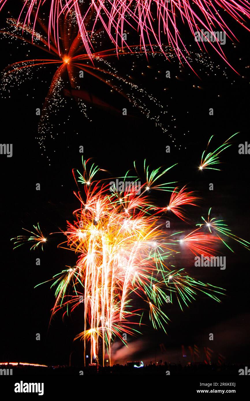 A vibrant display of multi-colored fireworks illuminates the night sky ...