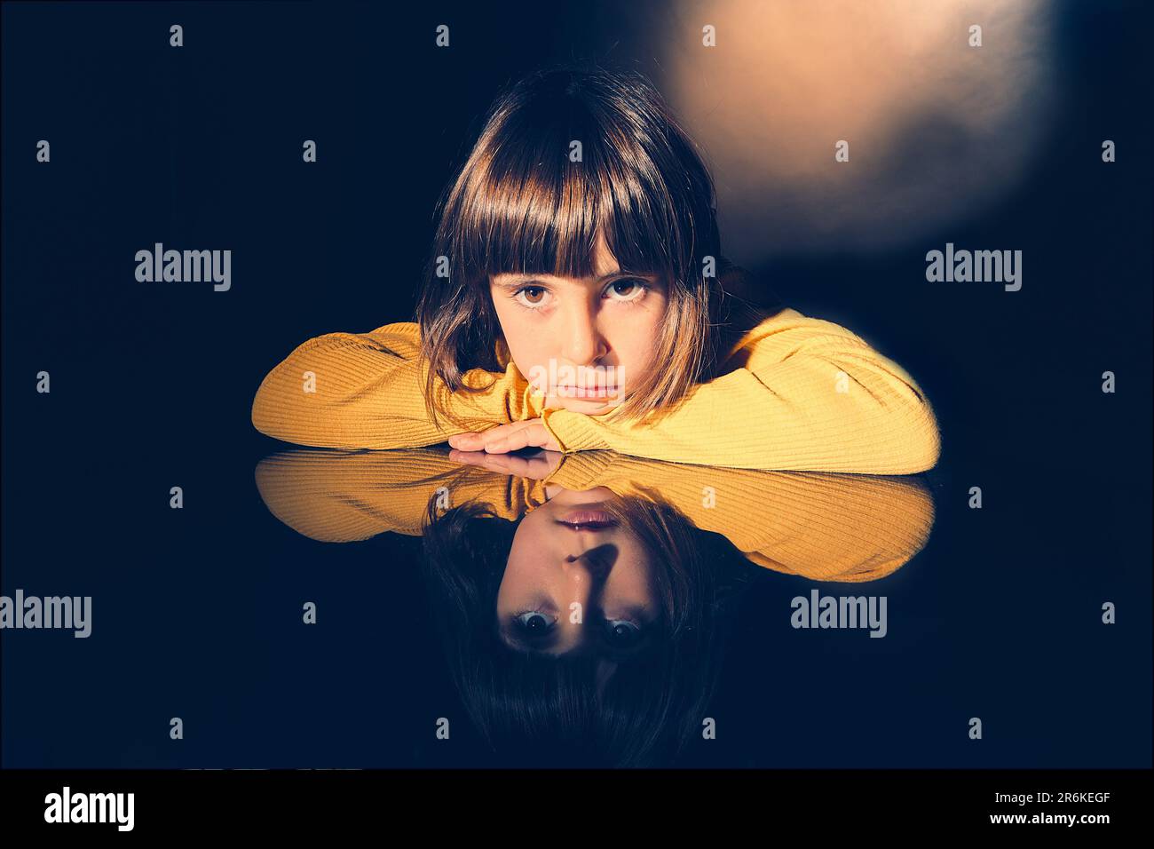 young girl with a depressed and sad face with her face reflected in a ...