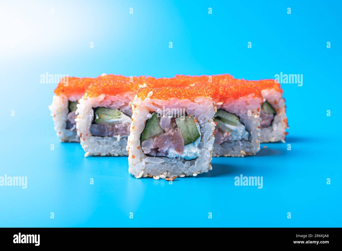 Sushi rolls with cucumber, shrimp, cheese and red tobiko, on a blue ...