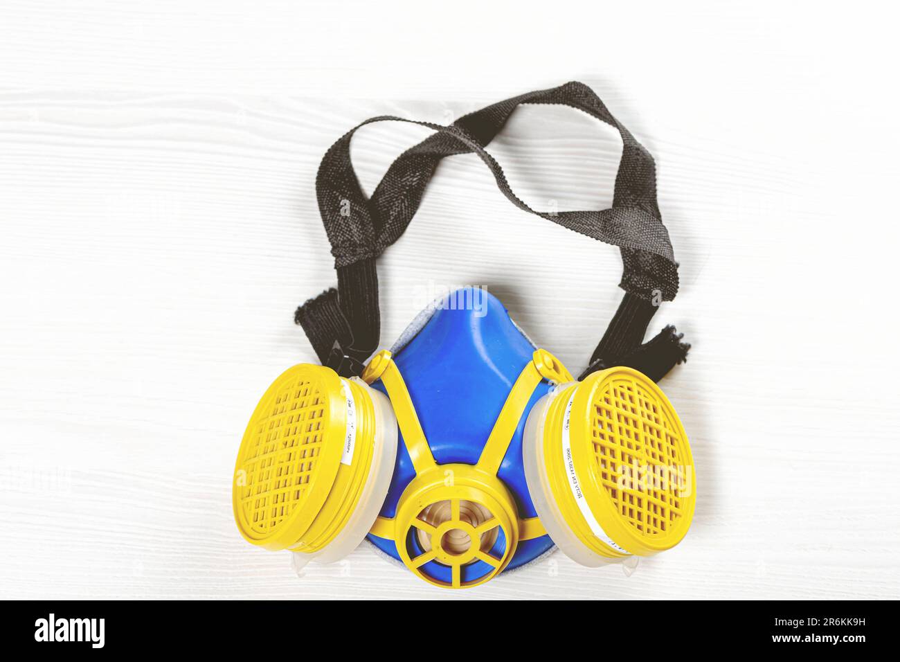 An isolated yellow gas mask facepiece with blue accents placed on a ...