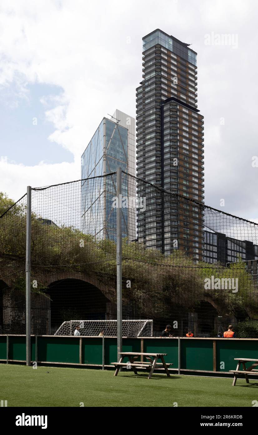 London, UK - May 17 2023: People play football in an inner city sports ...