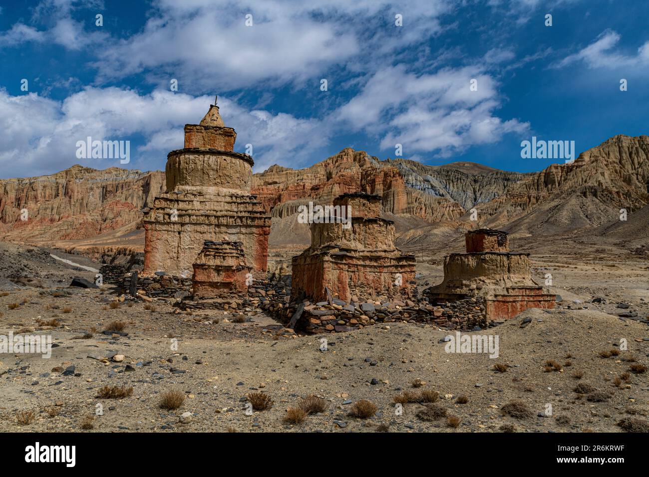 Colourfully painted Buddhist stupa, in an eroded mountain landscape ...