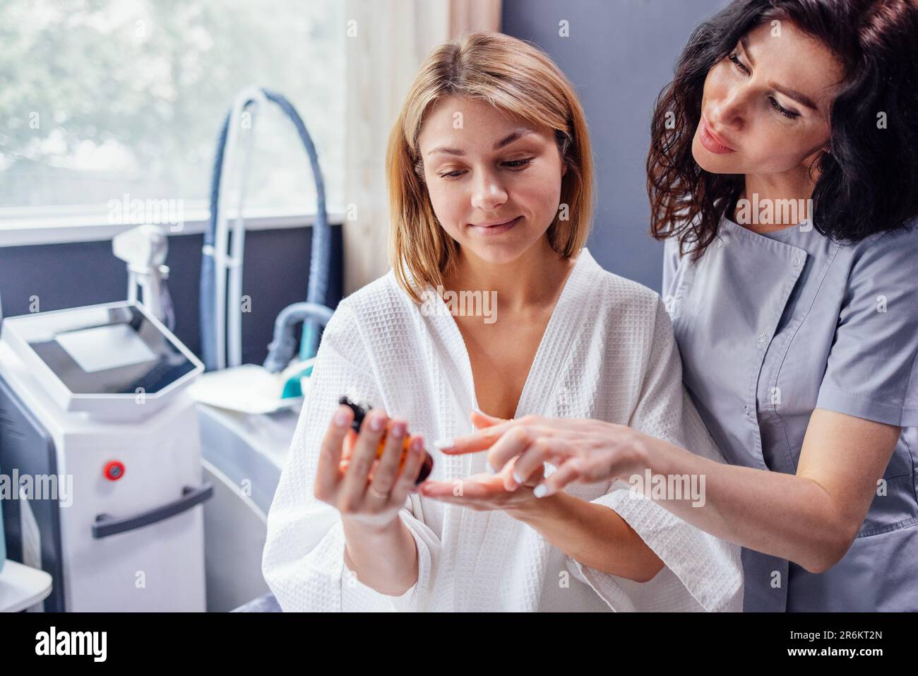 Pretty caucasian beautician communicates with her female client. Beauty ...