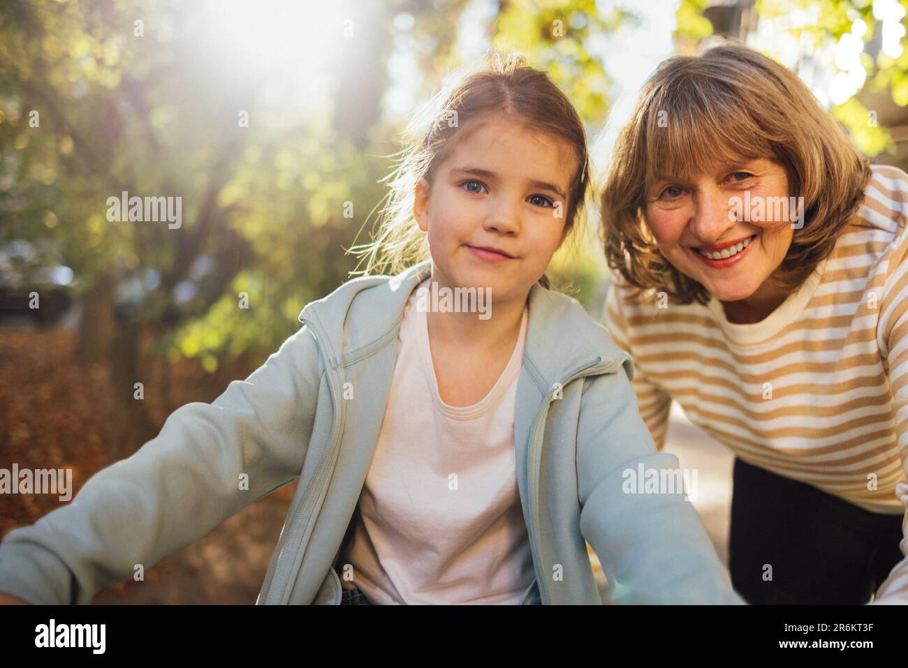 Little girl hugging smiling middle aged woman. Cute female kid and her ...