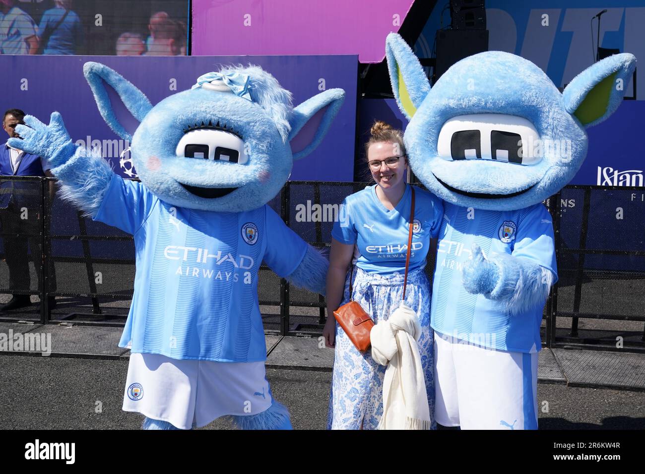 A Manchester City fan posing for a photo with mascots at the fanzone ...
