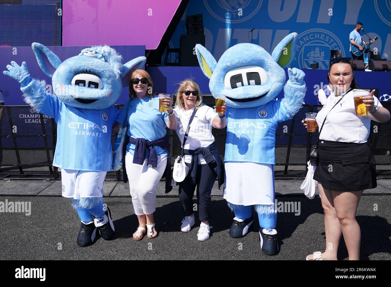 Manchester City fans posing for a photo with mascots at the fanzone ...