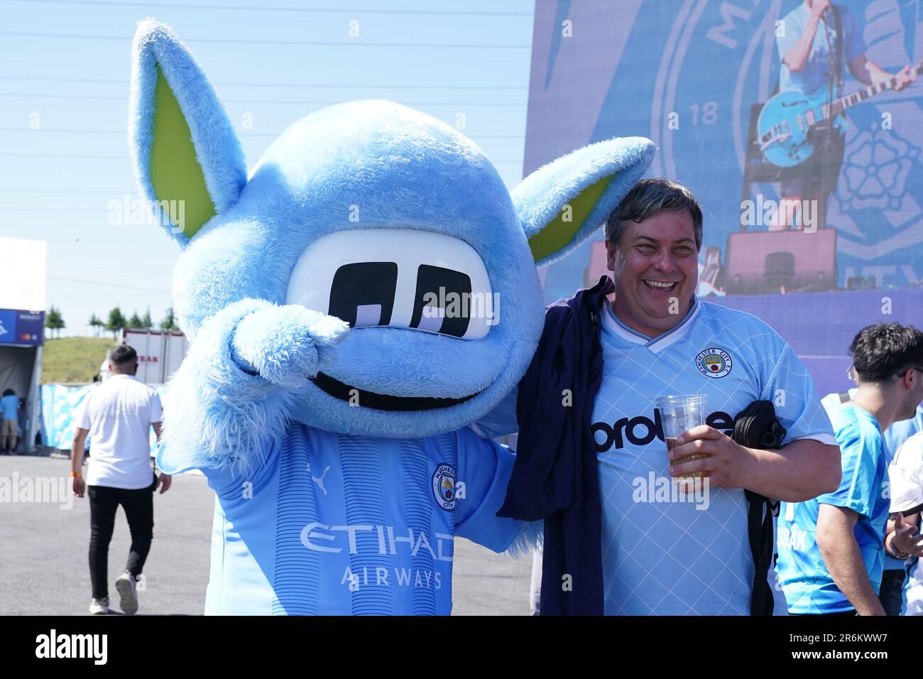 A Manchester City fan posing for a photo with mascots at the fanzone ...