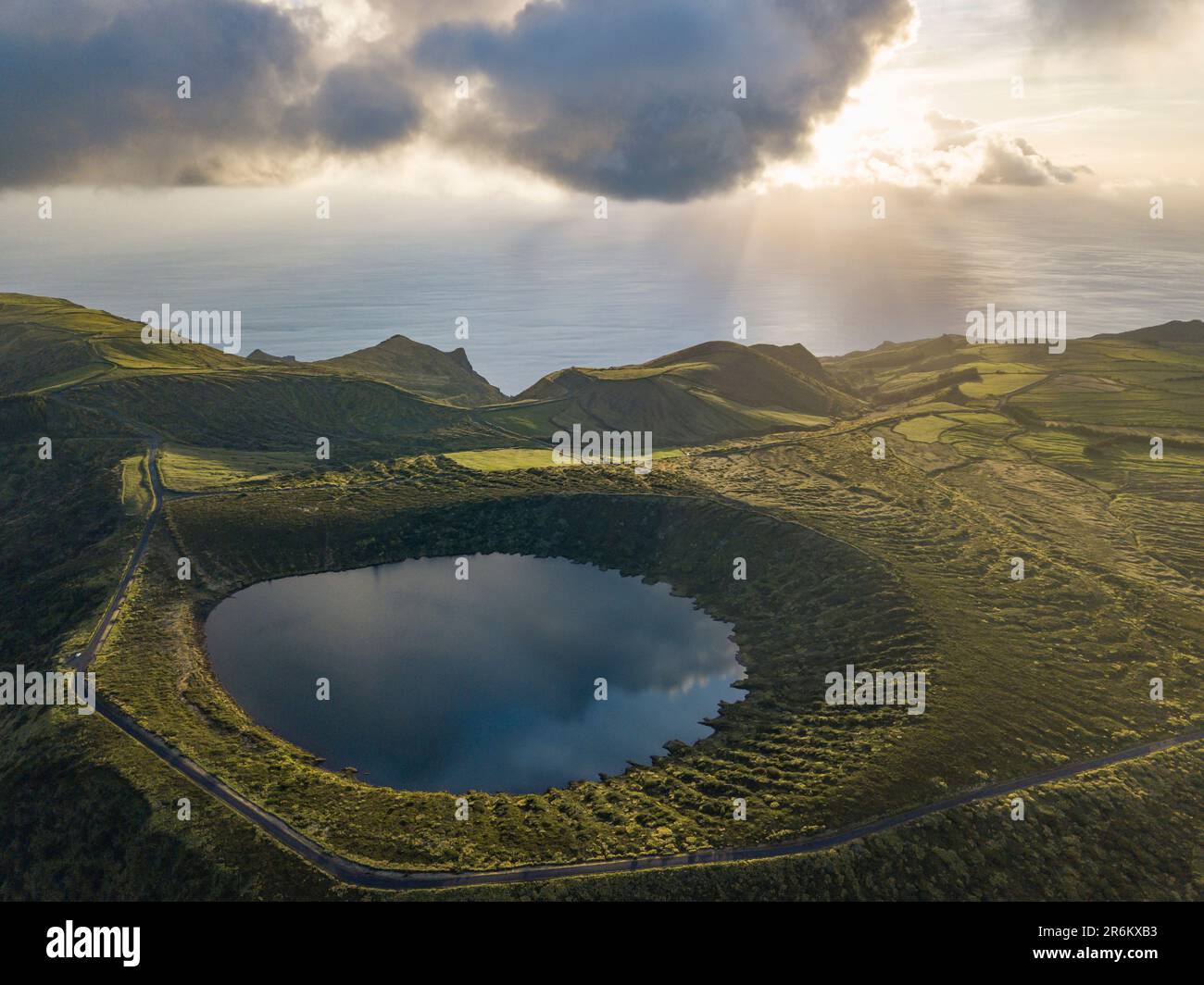 Aerial view of Caldeira Rasa lake on Flores island and the sunset over ...