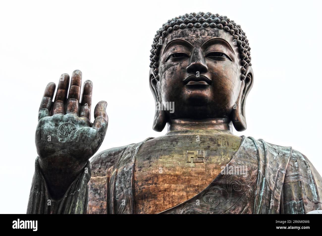 A majestic marble statue of a figure with arms raised to the sky ...