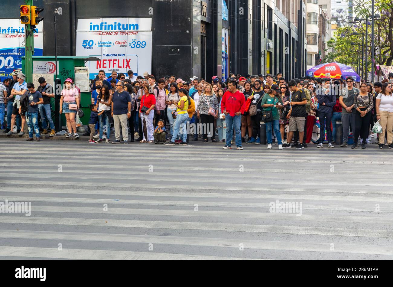 Large crowd of people waiting to cross busy road in city centre, Mexico ...