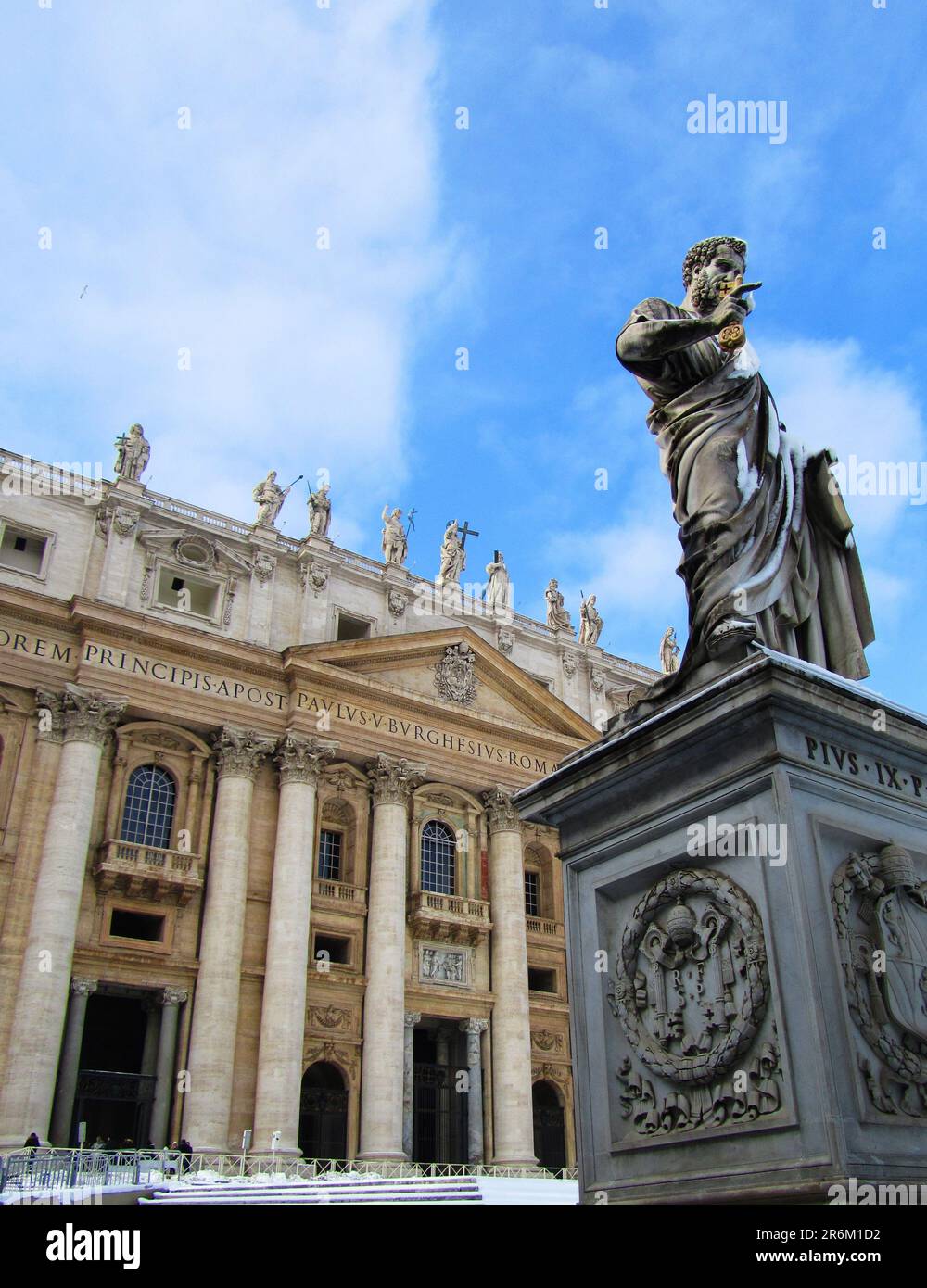 A bronze statue of a religious figure stands in front of a historical ...