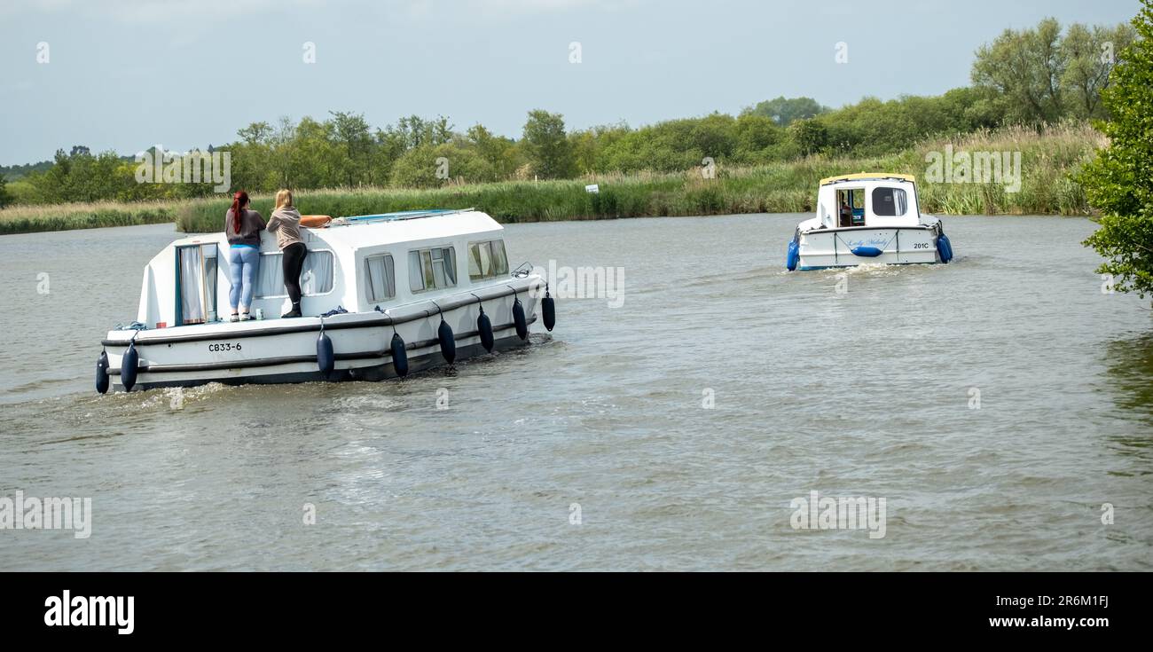 Two holiday cruisers motoring along the River Bure, Norfolk Broads ...