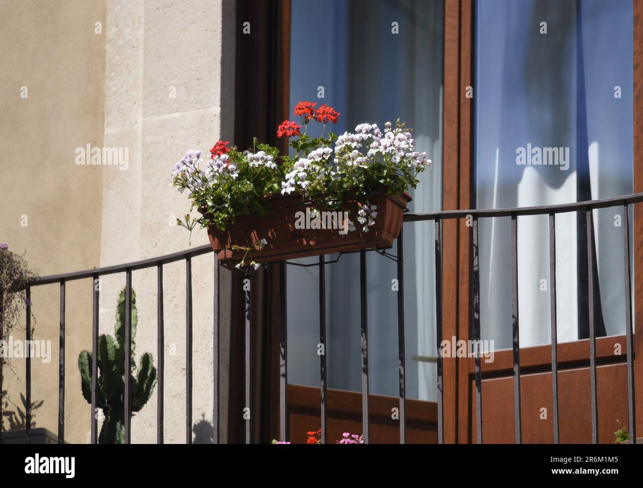 Traditional rural house balcony with a wrought iron railing and a pot ...