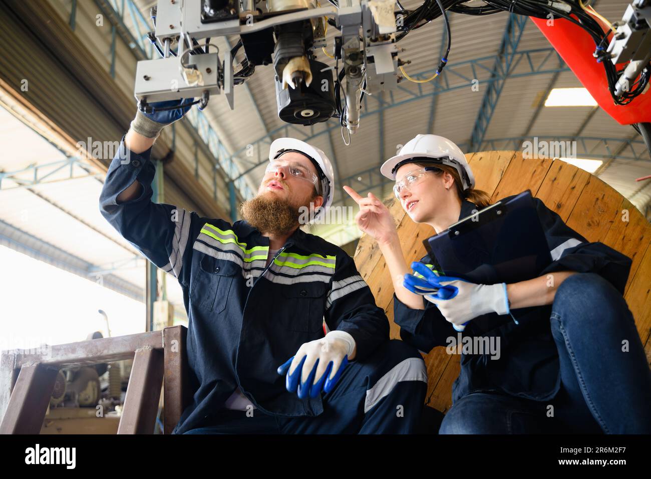 Mechanical engineers repairing engine machine at factory Stock Photo ...