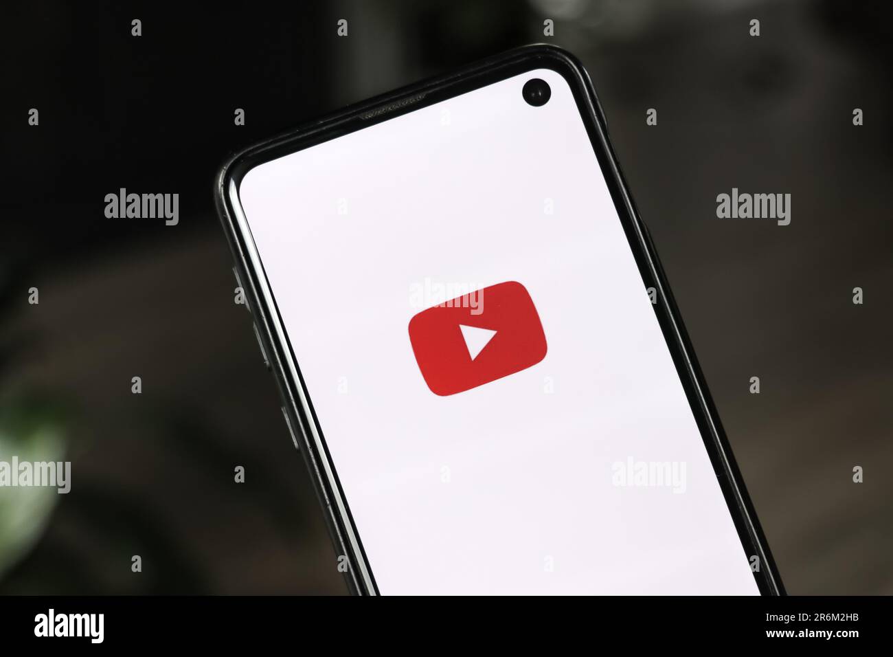 A closeup of a smartphone screen featuring the iconic Youtube logo ...