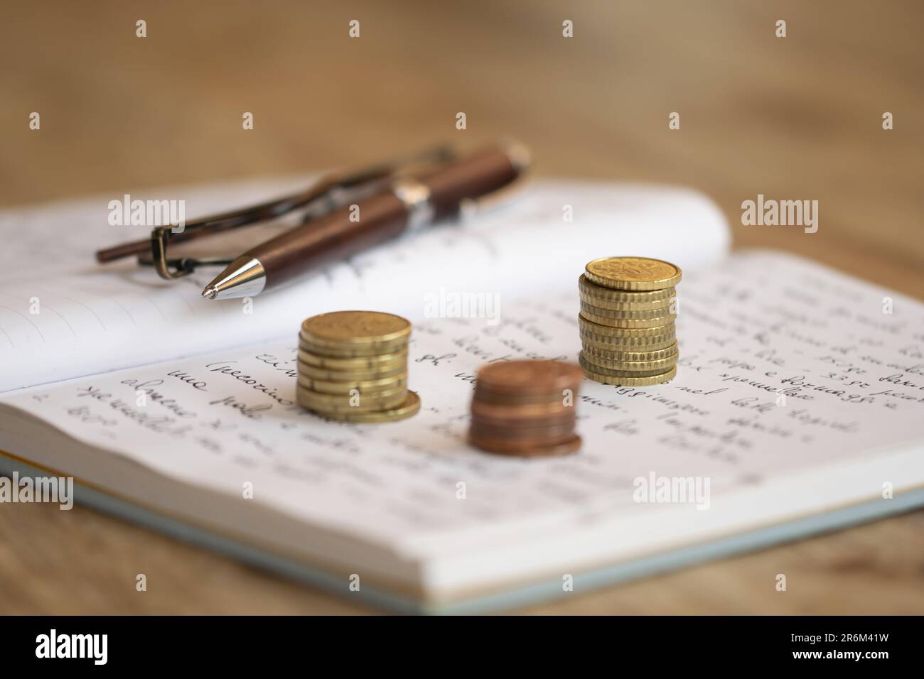 household economics concept with coins over a hand written notebook ...