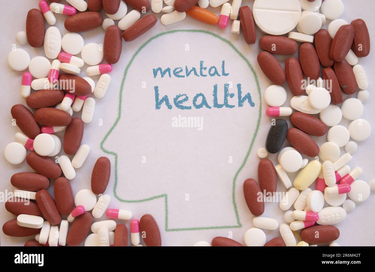 mental health concept with medicines surrounding drawing of a human ...