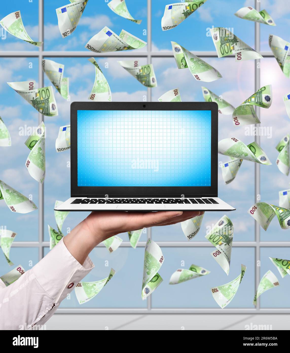 hand holding laptop with blank screen and falling euro bills Stock ...