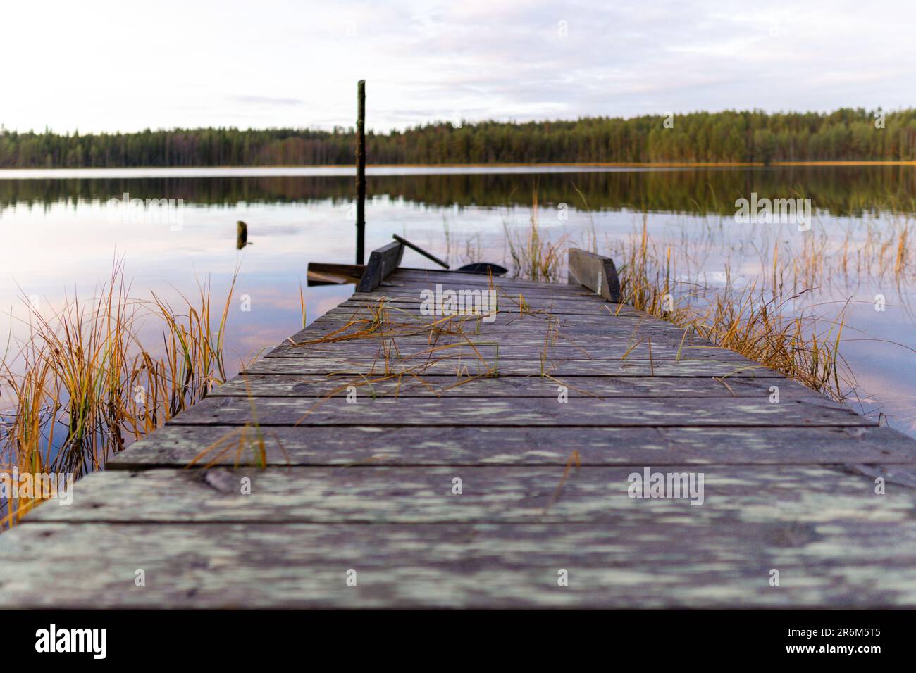 A weathered dock surrounded by the tranquil waters of a lake Stock ...