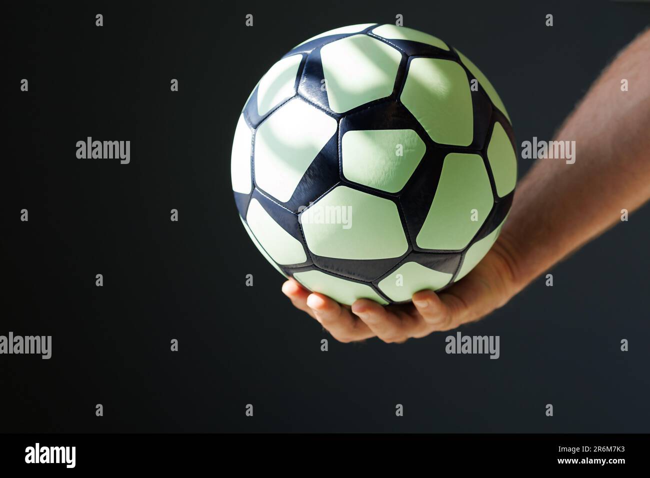 green black ball for handball in the athlete's hand on a black ...
