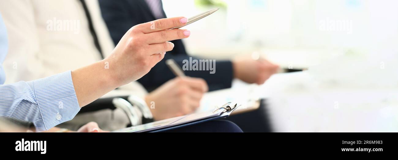 Row of business people hands holding documents and pens with documents ...
