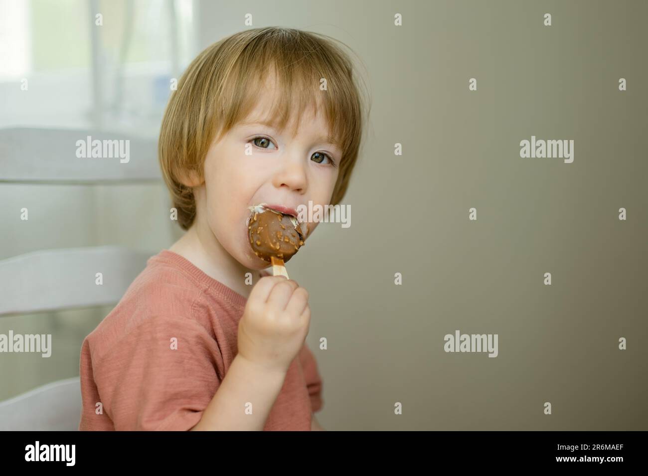 Cute toddler boy eating tasty fresh ice cream at home. Children eating ...