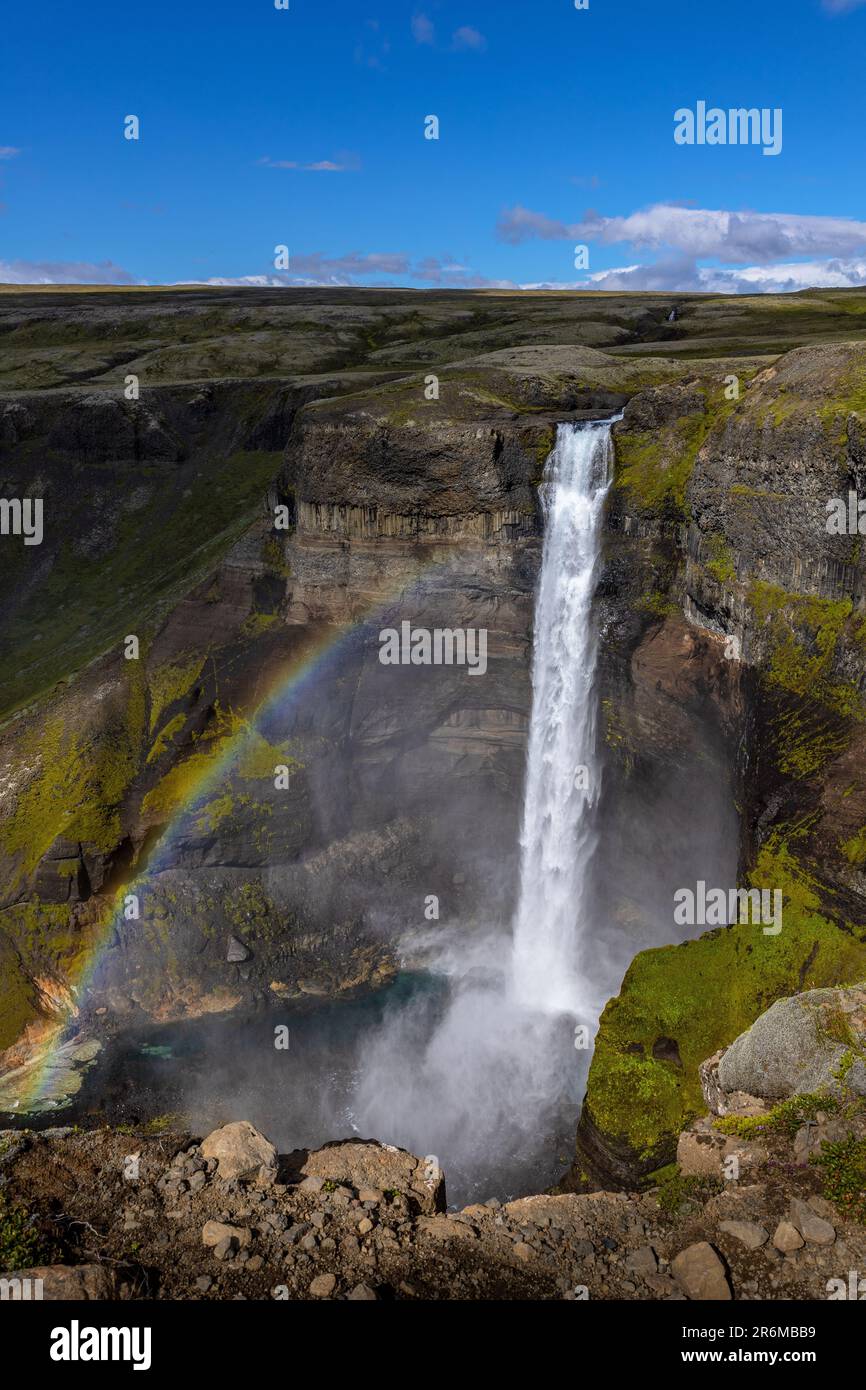 A scenic landscape featuring a dramatic waterfall, surrounded by lush ...