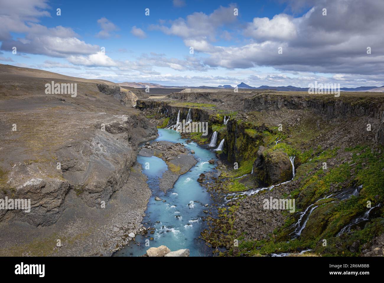 A scenic landscape of a deep gorge with a flowing waterfall Stock Photo ...