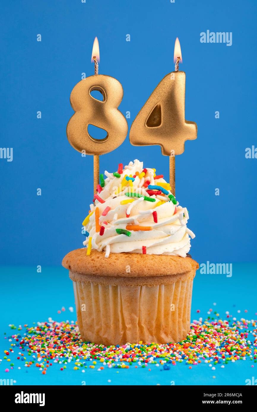 Birthday cake with candle number 84 - Blue background Stock Photo - Alamy