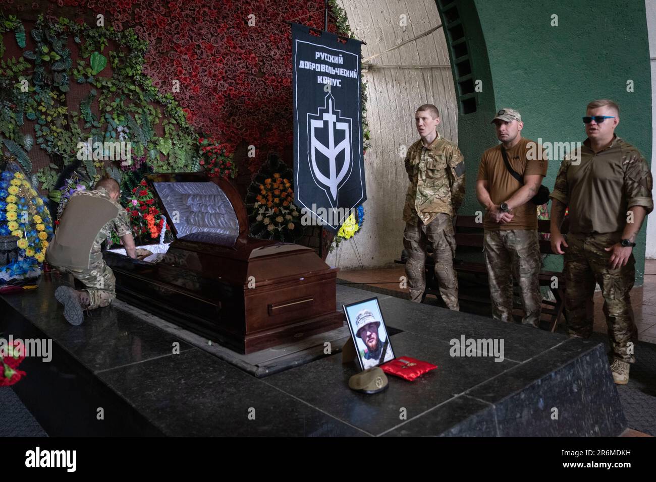 A fighter of the Russian Volunteer Corps stands kneeling as he pays the ...