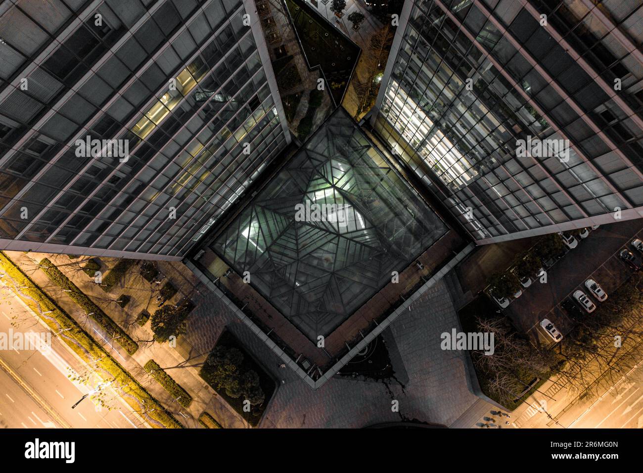 An aerial view of two commercial buildings at night illuminated by ...