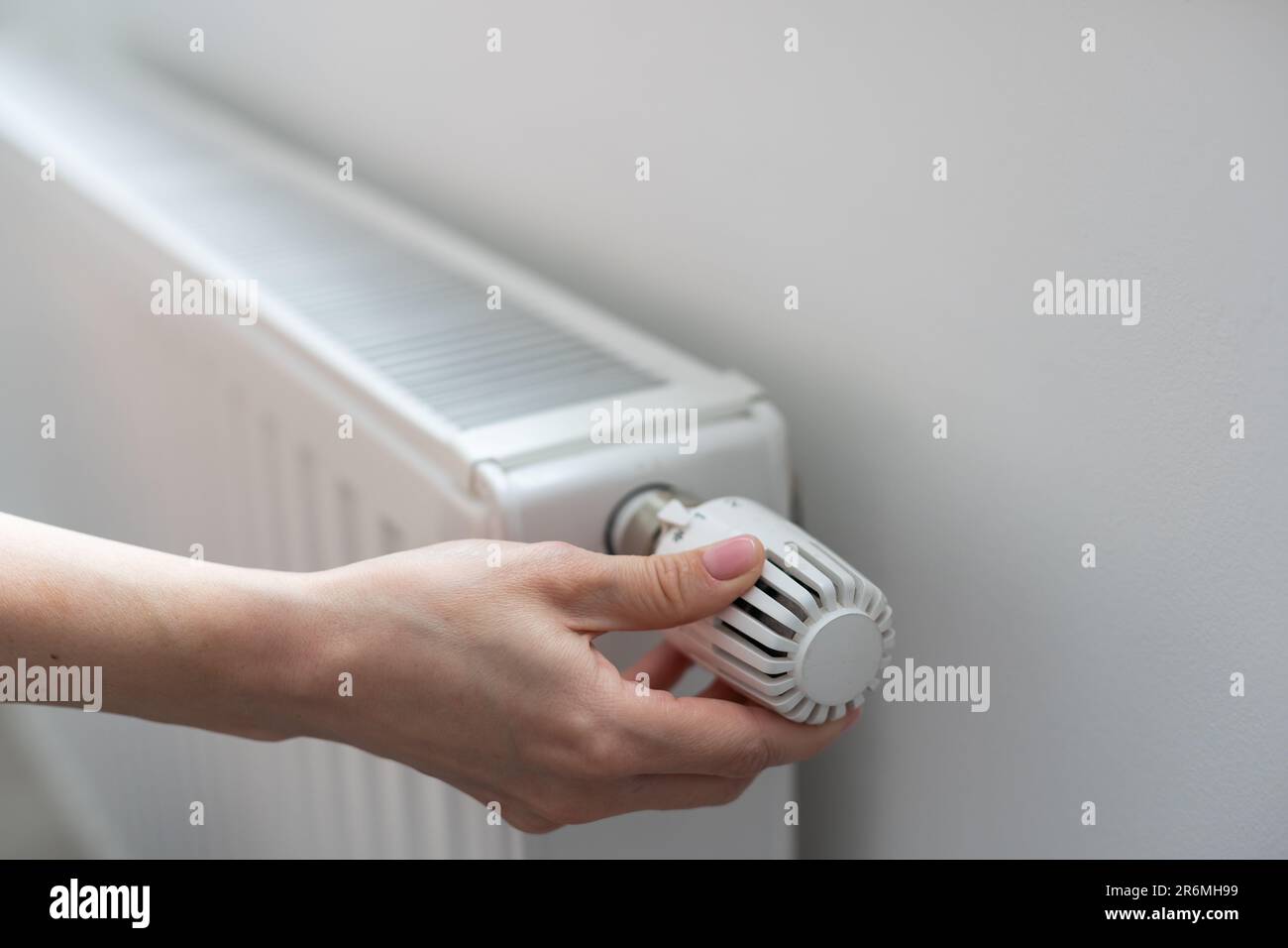 Woman's hand adjusting radiator temperature Stock Photo - Alamy