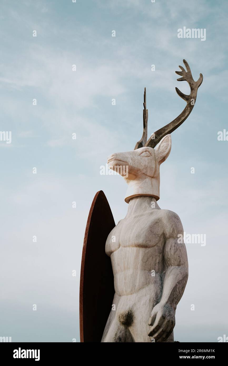 A vertical shot of the Surfer Deer Man sculpture from Nazareth under a ...