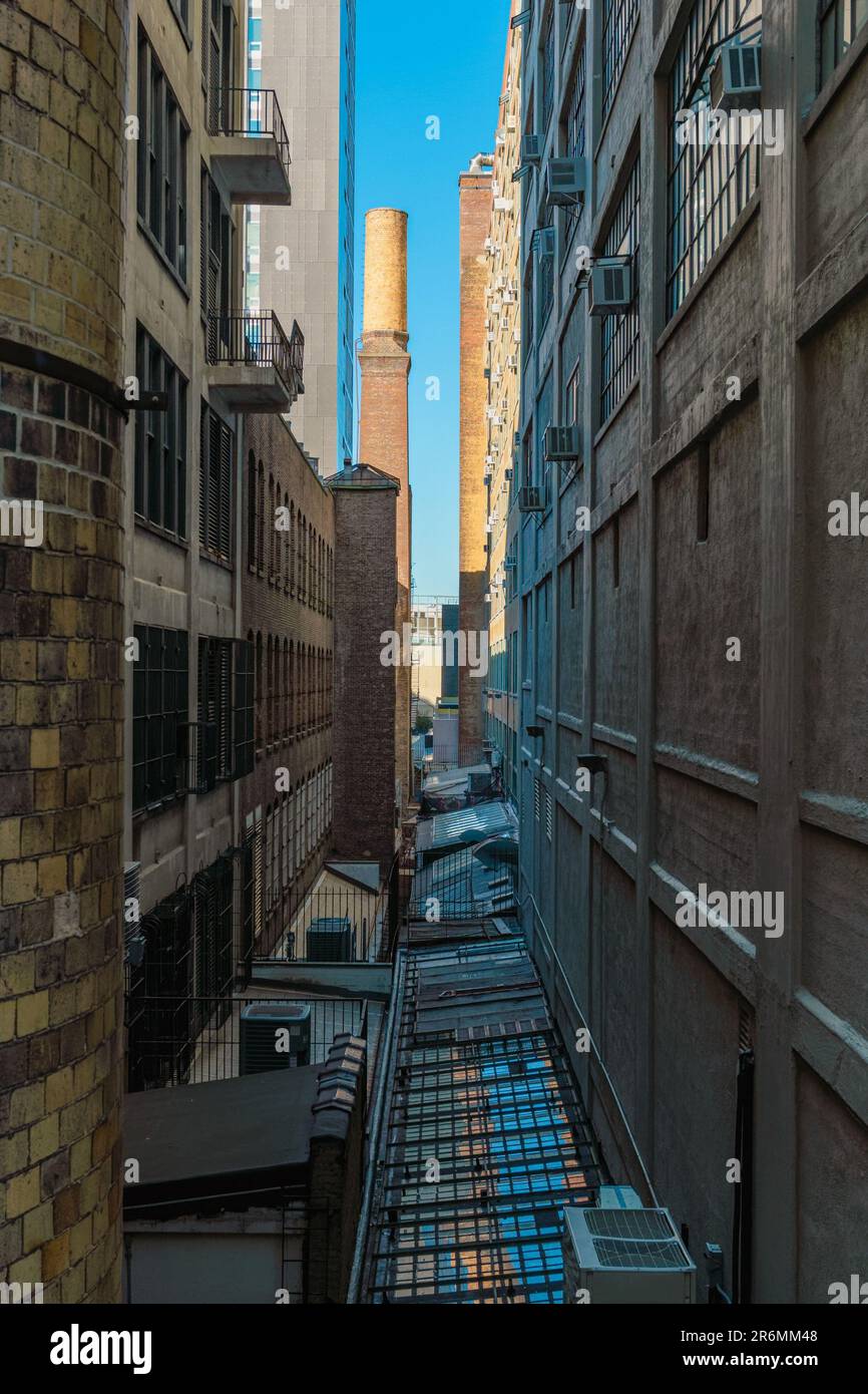 A close-up of an urban alleyway between two tall, steel-wired building ...