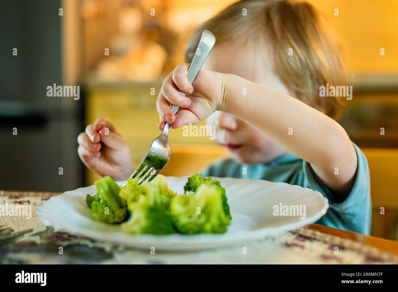 Cute little toddler boy eating broccoli. First solid foods. Fresh ...