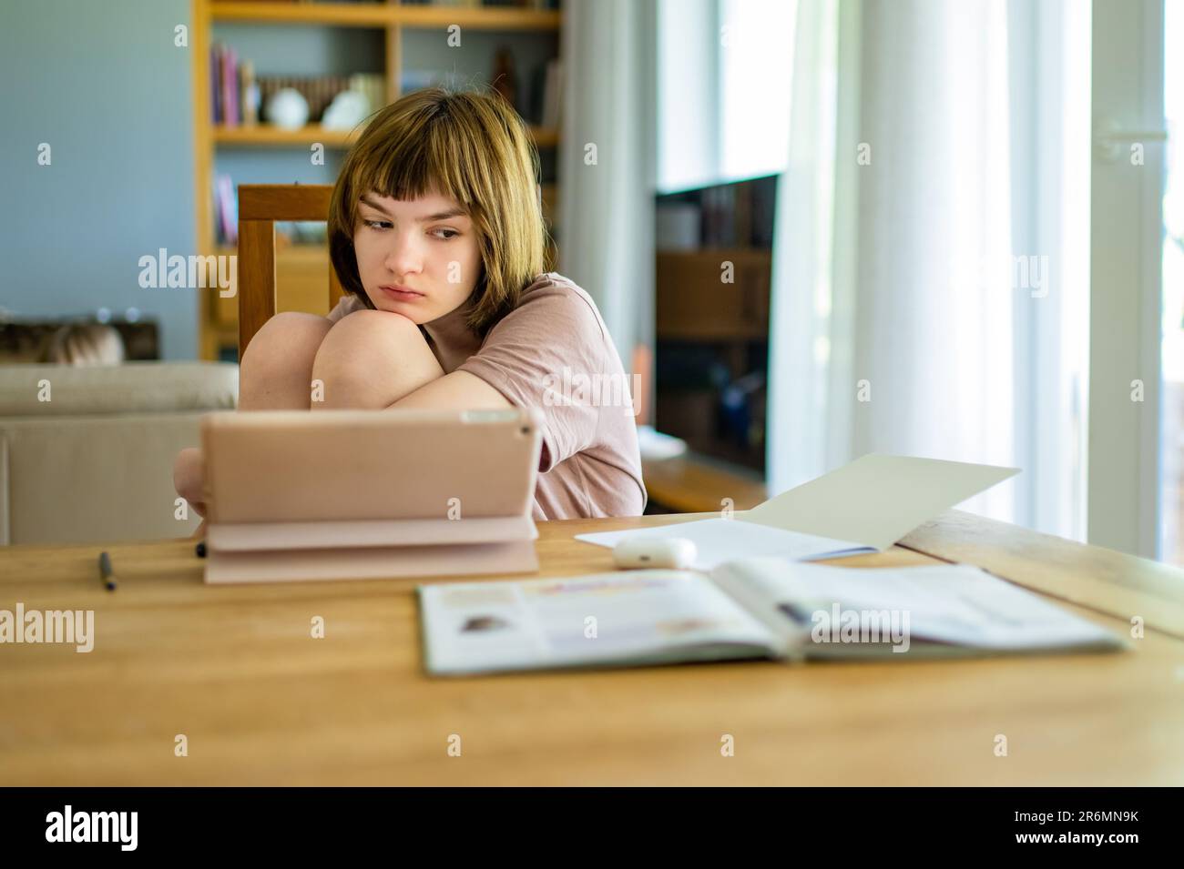Teenage schoolgirl doing her homework with digital tablet at home ...