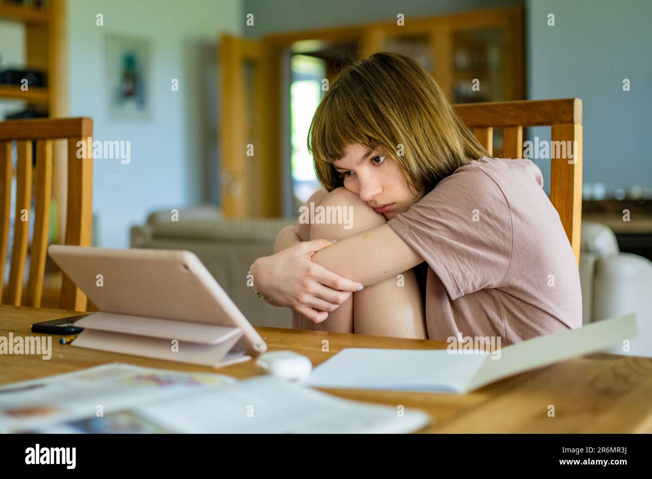 Teenage schoolgirl doing her homework with digital tablet at home ...