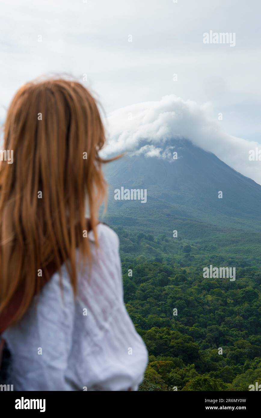 Female hiker looking out at the Arenal volcano in Costa Rica Stock ...