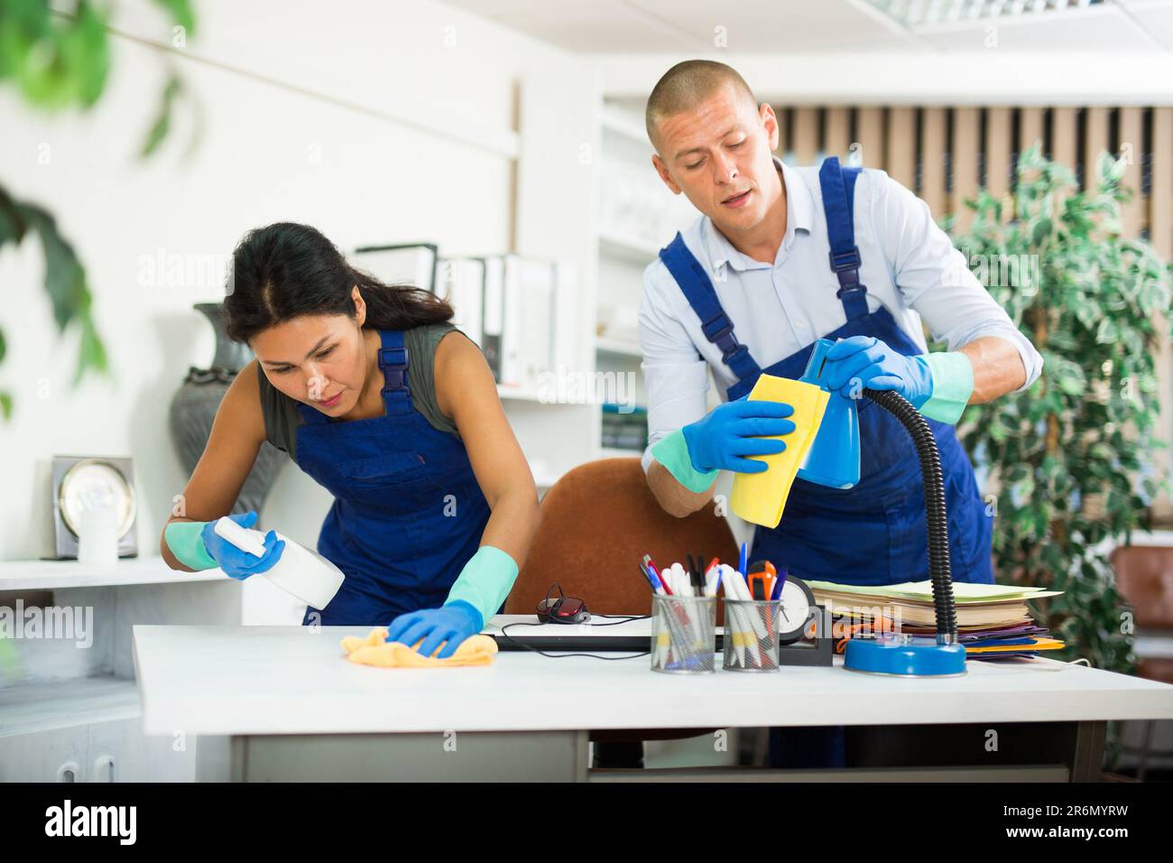 Workers cleaning desk in modern office Stock Photo - Alamy